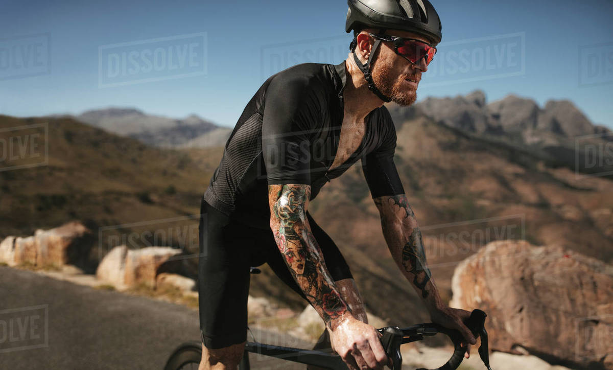 Male cyclist riding hard on pro bike outdoors. Fit and determined ...