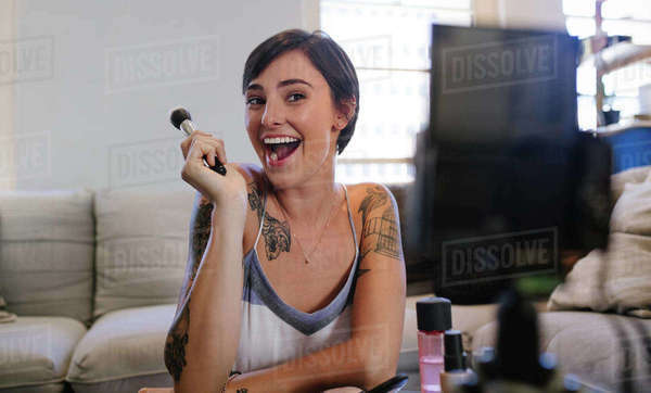 Excited young woman recording her video blog episode on camera about ...