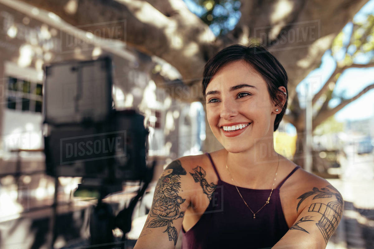 Happy woman vlogger filming video blog outdoors. Smiling female making ...