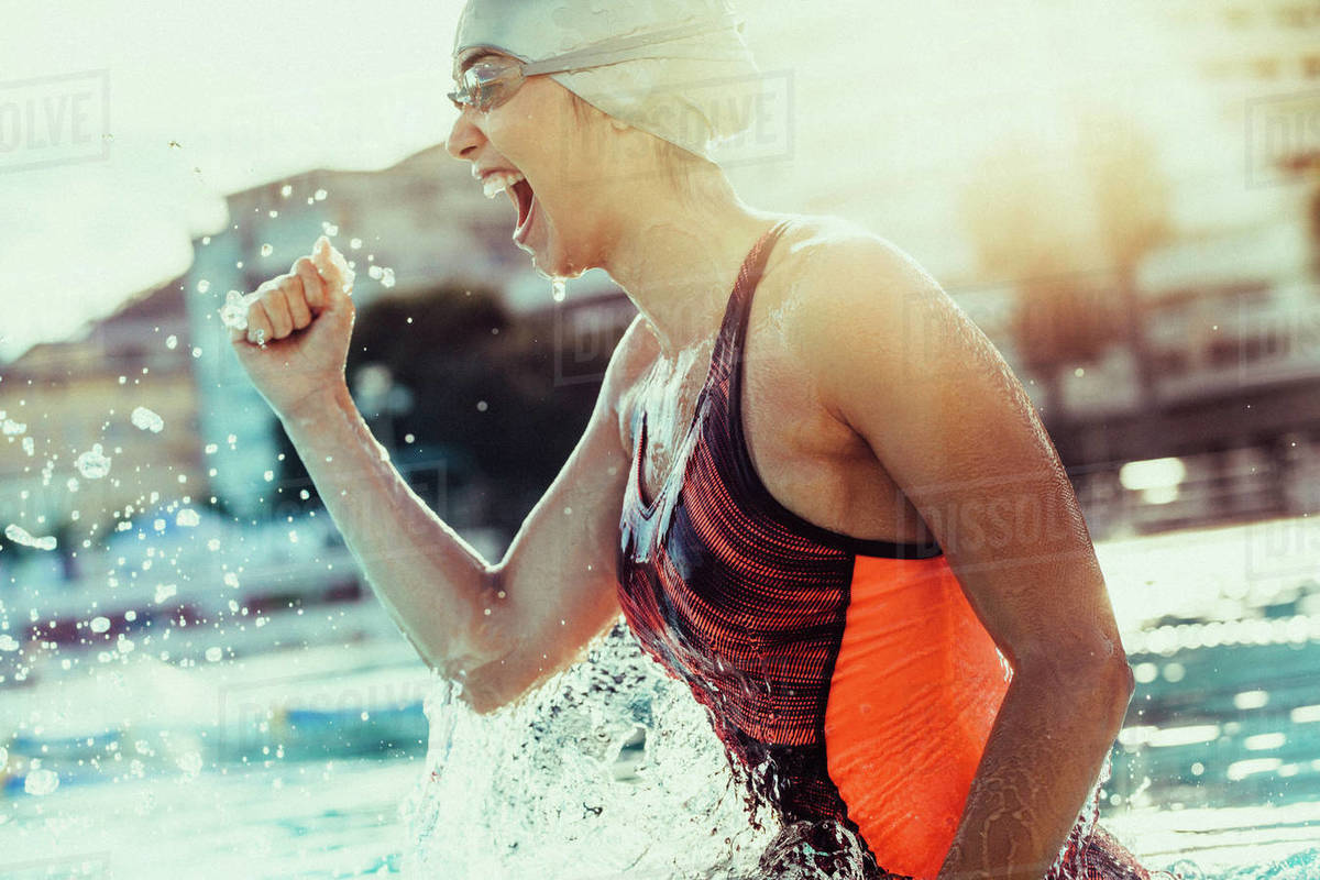 Excited female swimmer with clenched fist celebrating victory in the ...