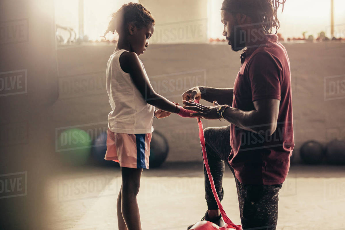 Boxing kid getting his hands wrapped with a bandage before putting on ...
