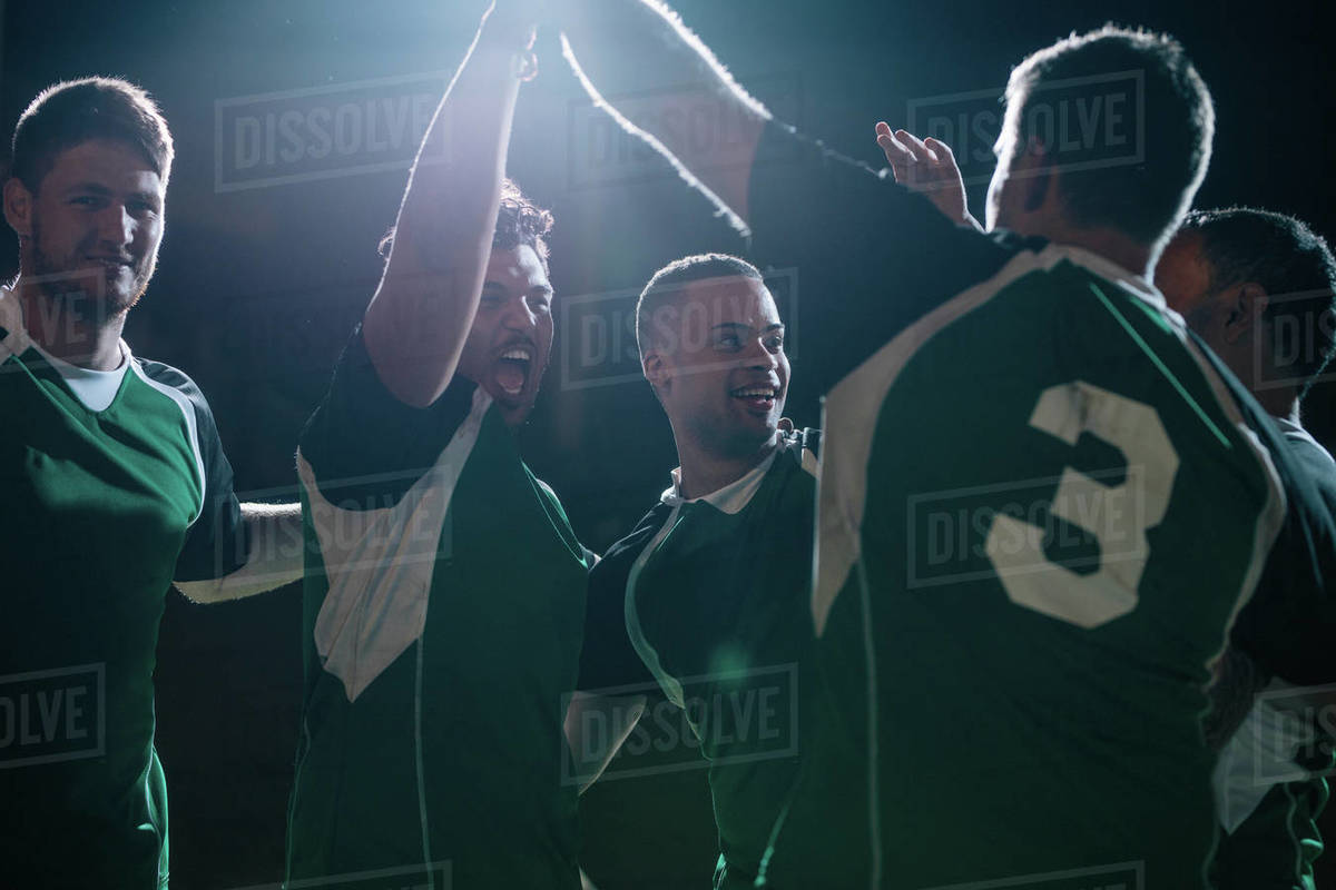 Rugby players celebrating a goal at the sports field. Rugby team with ...