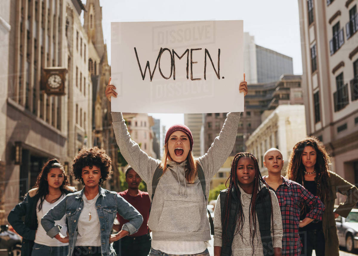 Angry woman shouting with a hand written protest sign at women's march ...