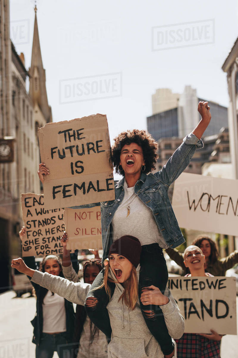 Group of aggressive protesters marching on the road with signboards ...