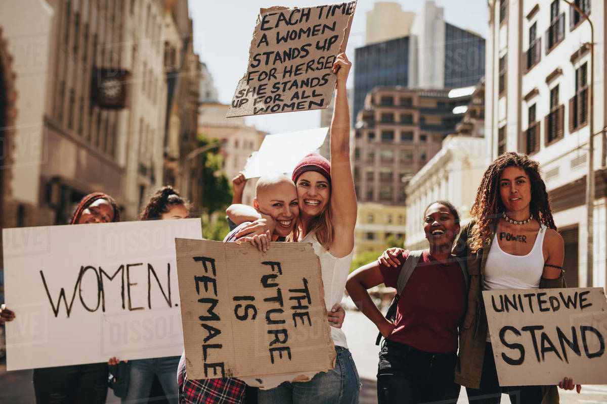 Crowd of protesters hold signs and rally on road. Group of women ...
