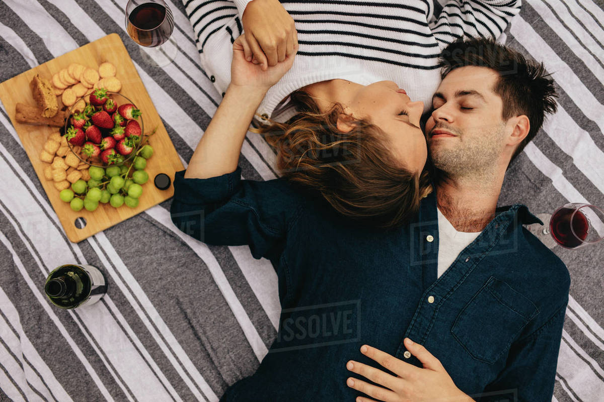 Top view of a romantic couple lying down in opposite directions with ...