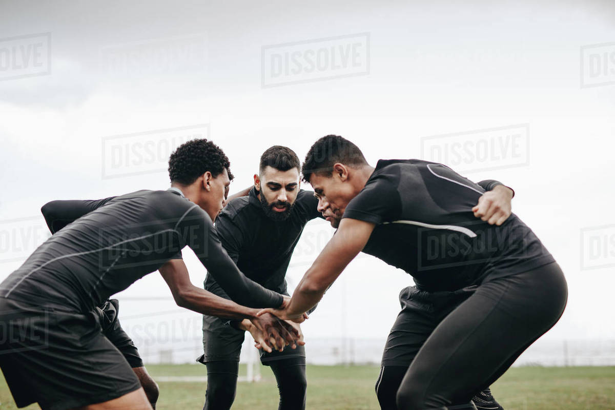 Soccer players discussing game strategy standing in a huddle on the ...