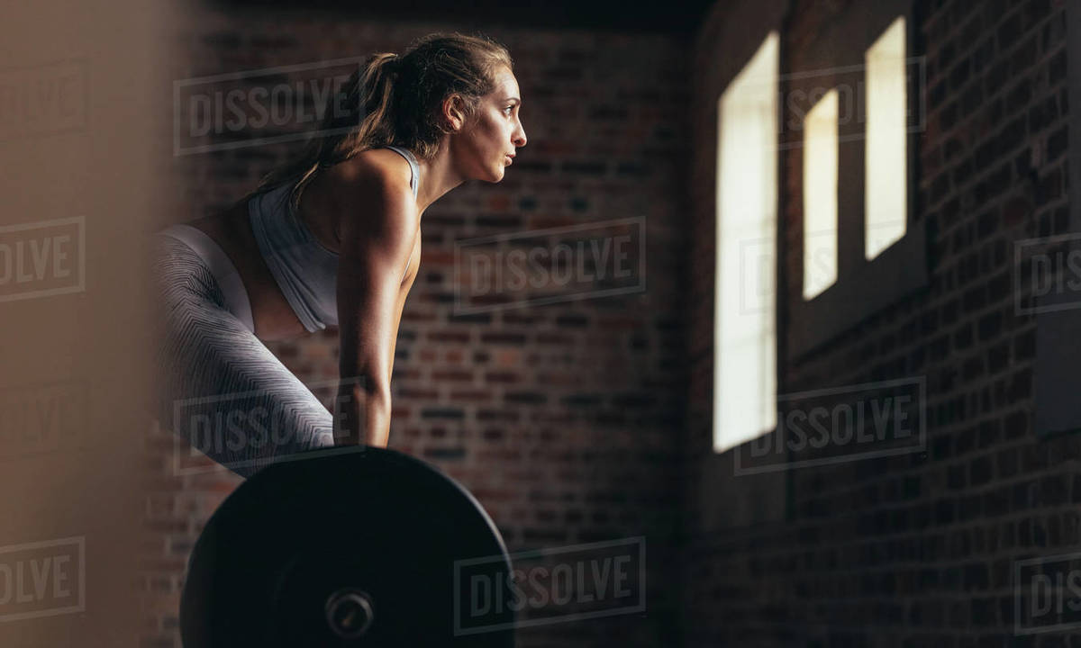 Determined fitness woman training with heavy weights in fitness club ...