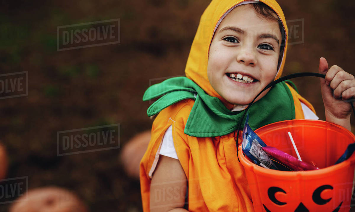 Close up portrait of cute little girl in Halloween costume holding ...