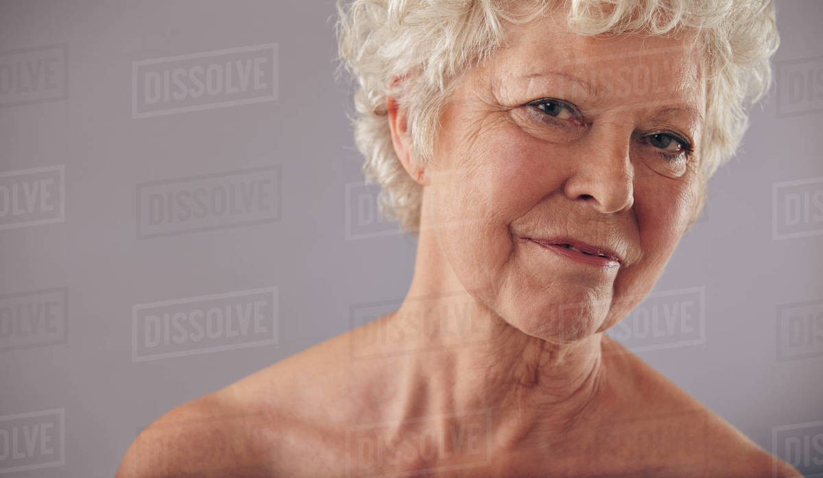 Close-up portrait of old caucasian female face against grey background ...