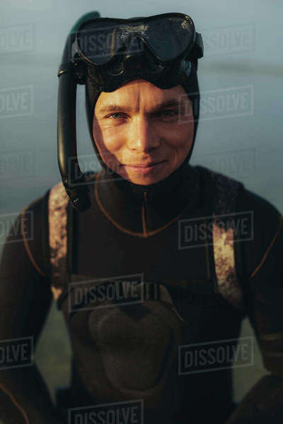 Close-up vertical shot of happy young man in scuba gear looking at ...