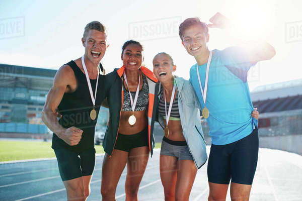 Portrait of young team of athletes enjoying victory. Diverse group of ...