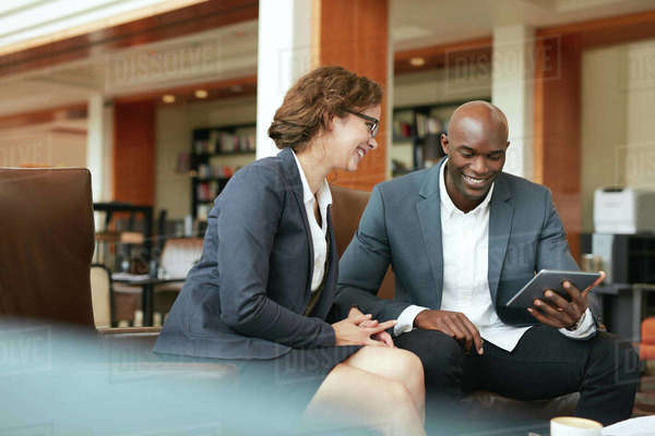 Shot of two people looking at something on a touchscreen computer ...
