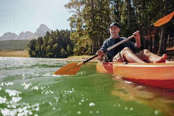 Portrait of a mature man with enjoying kayaking in a lake. Caucasian ...