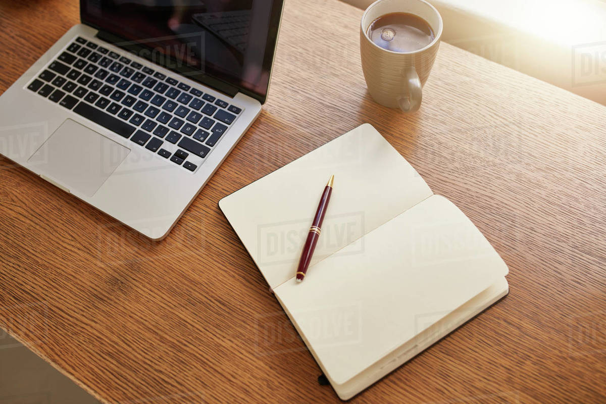 Top view shot of laptop computer, diary an cup of coffee on wooden ...