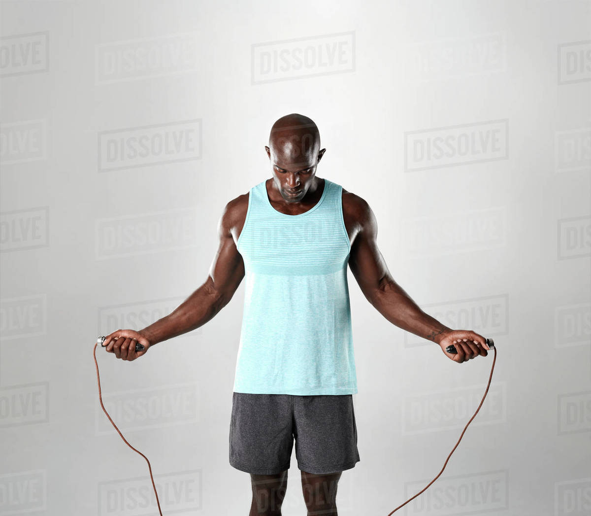 Portrait of masculine man skipping rope. Muscular young man exercising ...