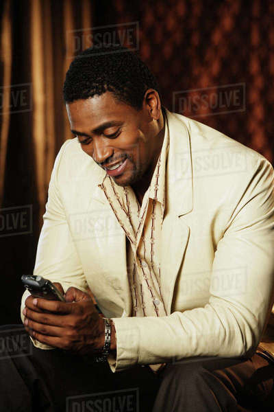 African man dialing cell phone - Stock Photo - Dissolve