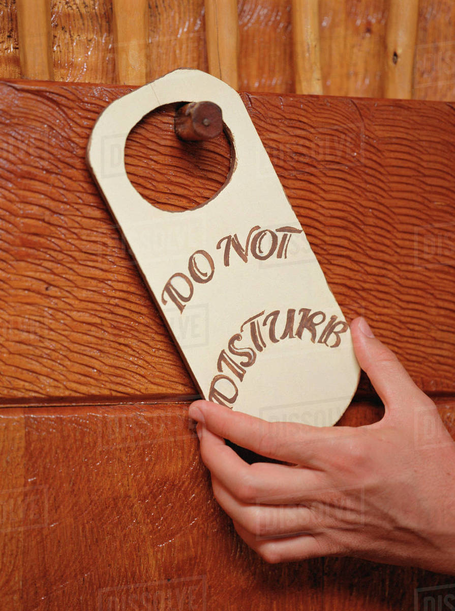 Hand putting Do Not Disturb sign on doorknob - Royalty-free Stock Photo ...