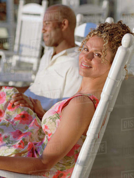 Middle-aged African American couple sitting in rocking chairs outdoors ...