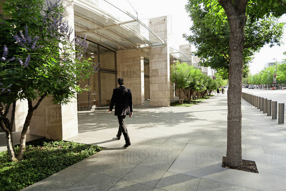 Businessman walking into office building - Royalty-free Stock Photo ...