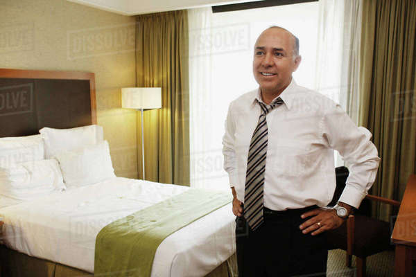 Businessman standing in hotel room - Royalty-free Stock Photo | Dissolve
