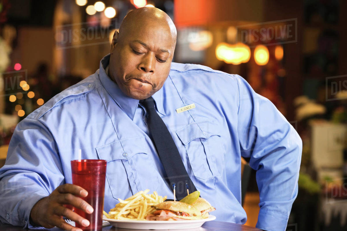 Black police officer eating unhealthy food - Royalty-free Stock Photo ...