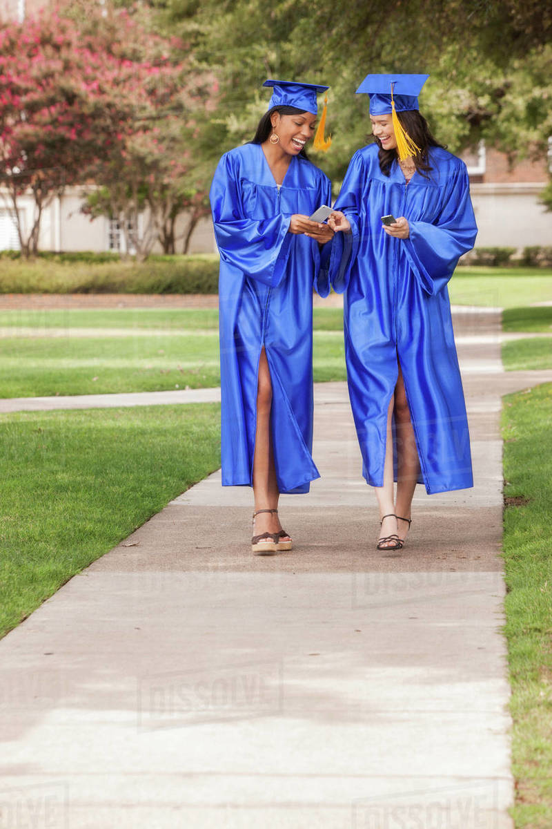 College graduates walking on campus - Stock Photo - Dissolve