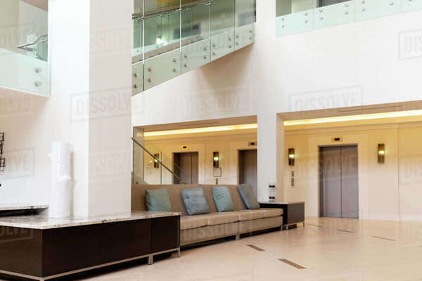 Empty Hotel lobby, with staircase and bank of elevators in background ...