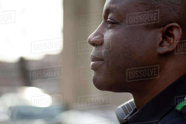 Close up profile Portrait of uniformed Police officer sitting outside ...