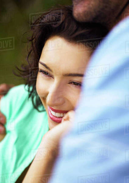 Woman smiling while being embraced by man - Royalty-free Stock Photo ...