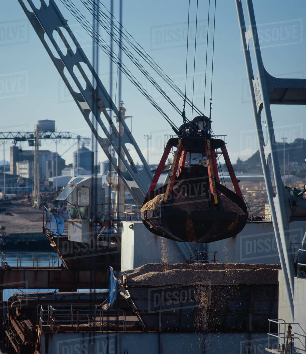 Close up of large claw bucket loading wood chips onto ship at port - Royalty-free Stock Photo ...