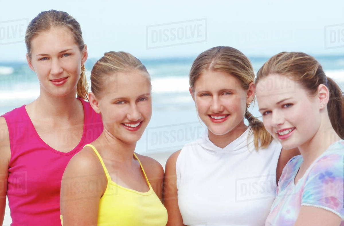 Four teenage girls up close and smiling at the beach - Royalty-free ...