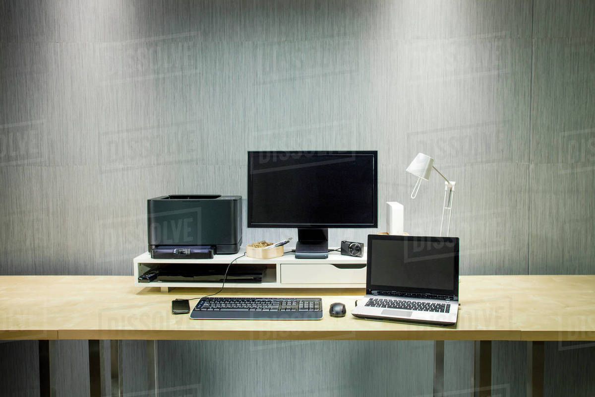 Still life of a home office setup with a desktop computer, laptop, and ...