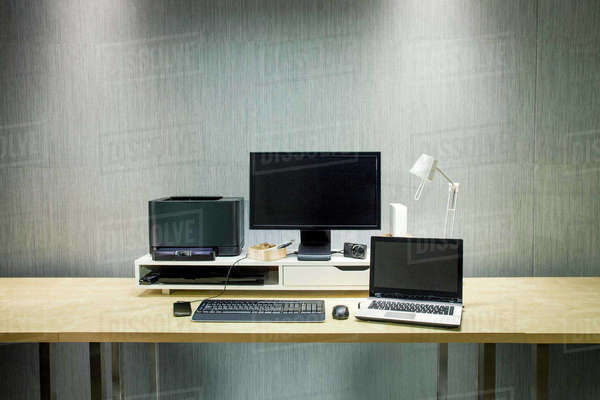 Still life of a home office setup with a desktop computer, laptop, and ...