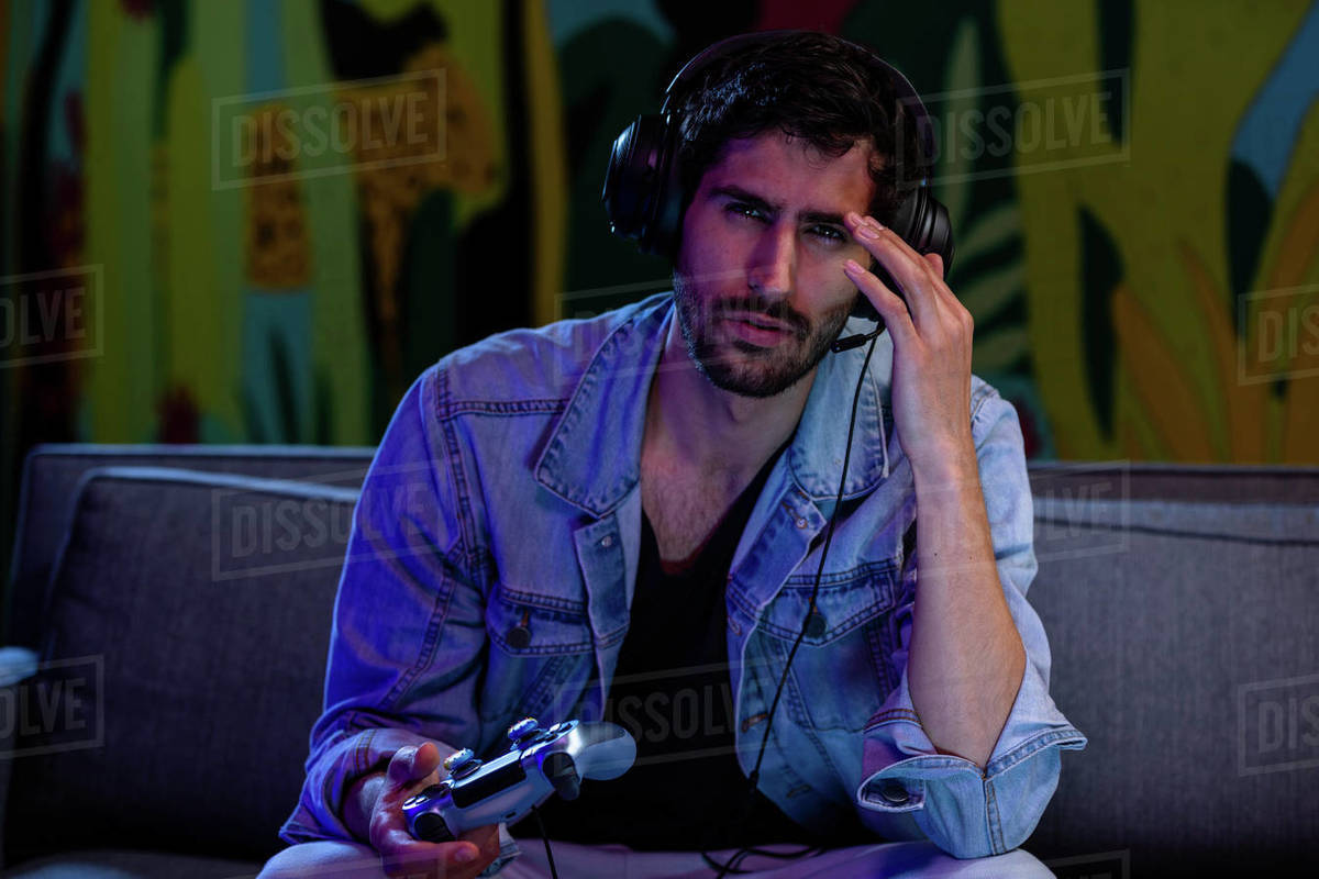 Focused and confused gamer playing on sofa at home - Royalty-free Stock ...