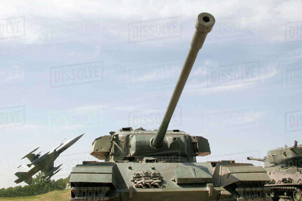 War tank with a fighter jet in the background - Stock Photo - Dissolve