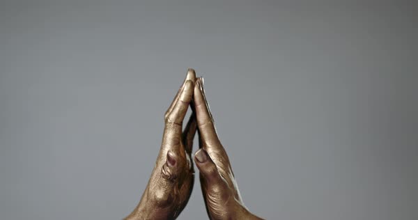 Two hands covered in gold paint, coming together in unity - 4K Royalty ...