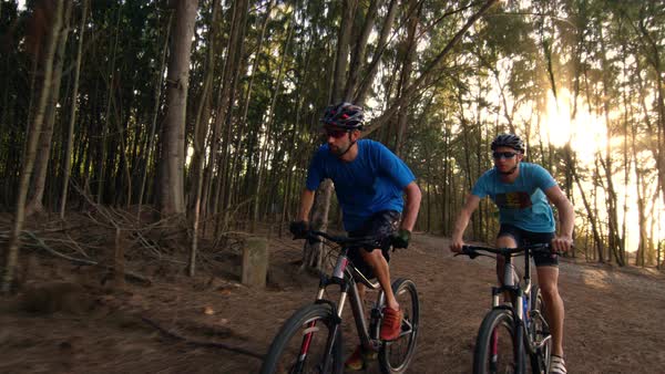 Two mountain bikers racing while sun sets in background - 4K Royalty ...