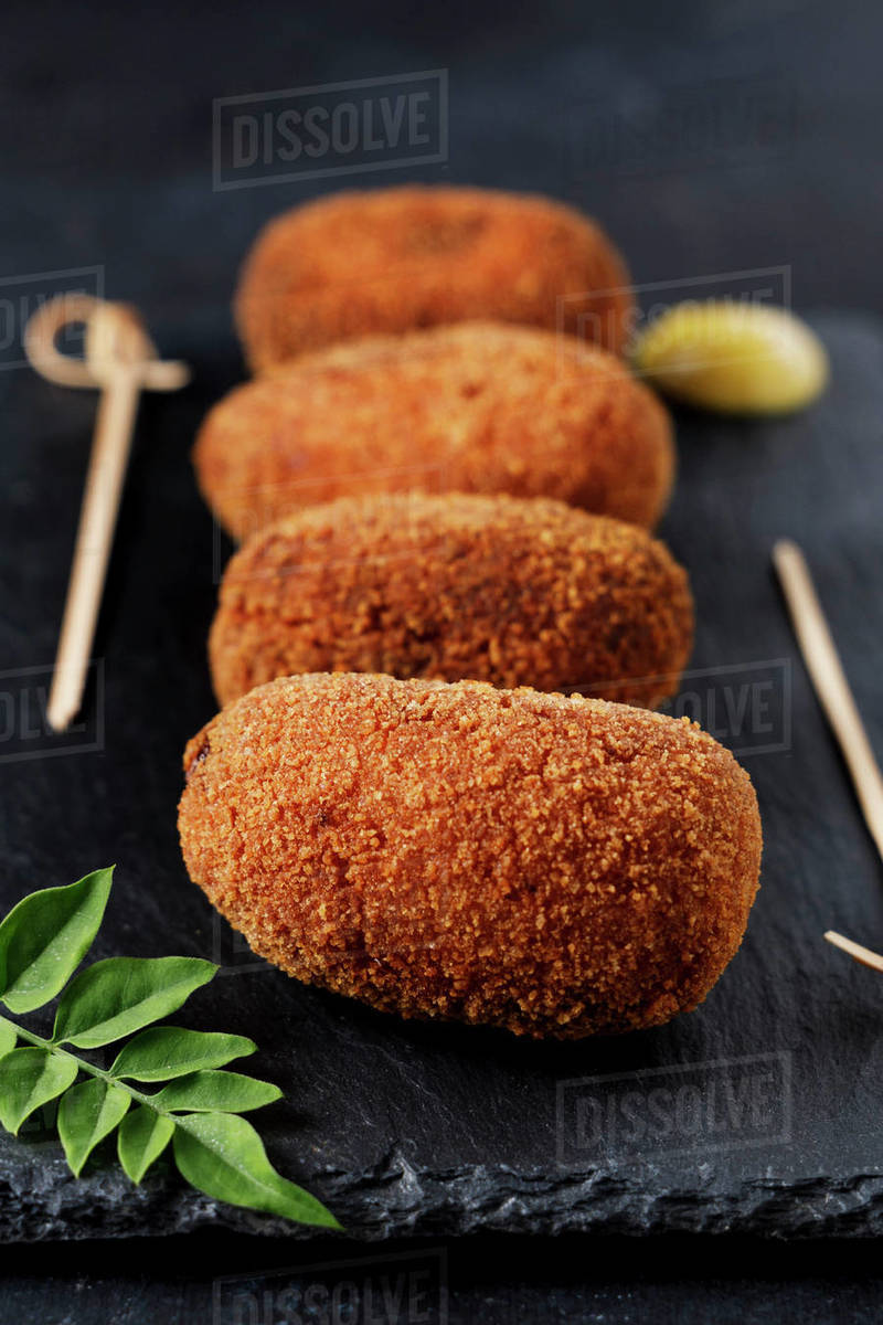 Portrait of gourmet style ham croquettes with black background ...