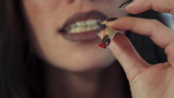 Girl smoking hashish joint at home for smoking. Young woman using ...