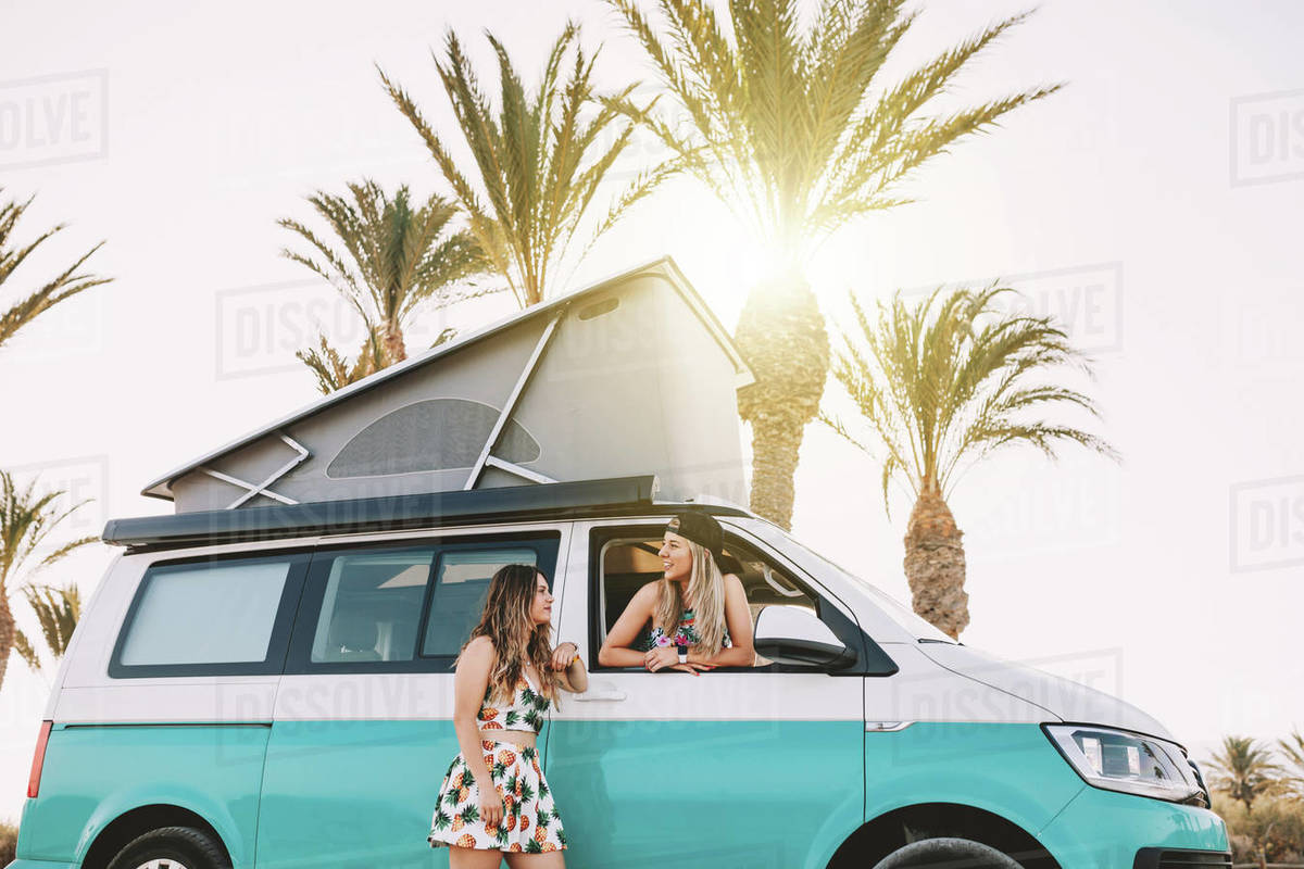 Two young women having fun in her van near the beach - Royalty-free ...