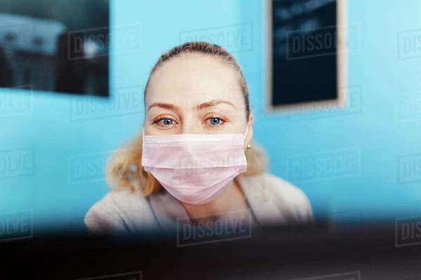 Woman wearing surgical mask with covid 19 model in her hand - Royalty ...