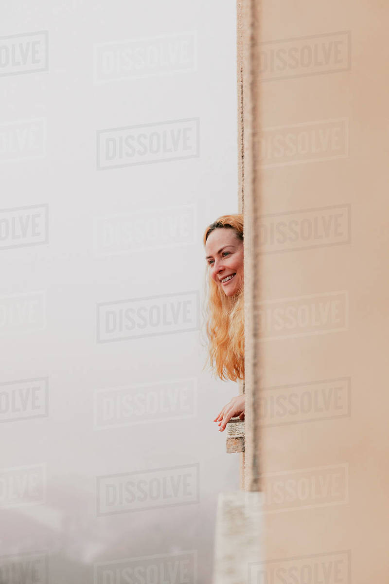 Quarantined woman bending over the window watching outside - Stock ...