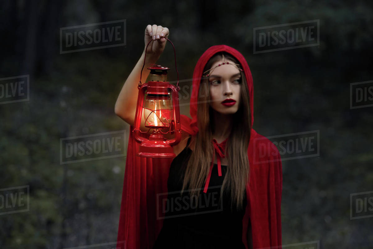 Elegant mystic girl walking in dark forest with kerosene lamp - Royalty ...