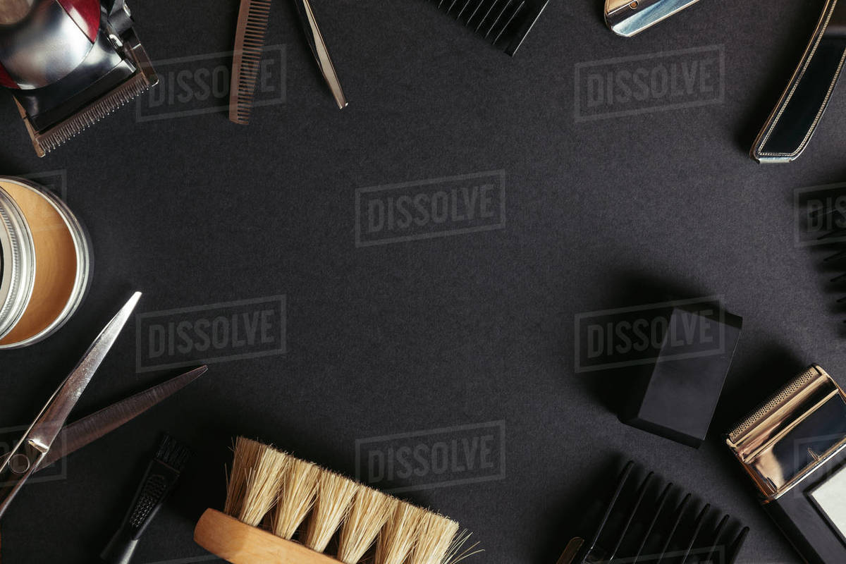 Top view of various professional barber tools on black background ...