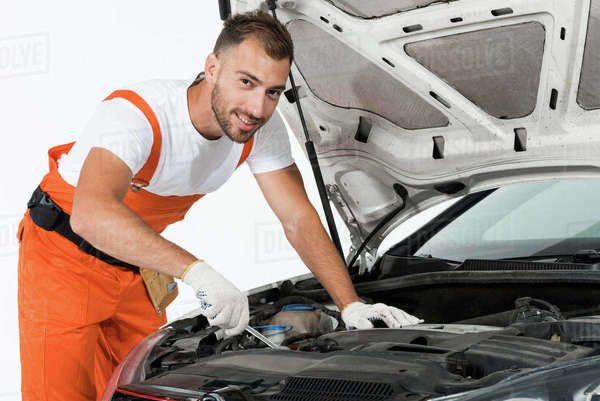 Handsome auto mechanic auto mechanic repairing car with wrench on white ...