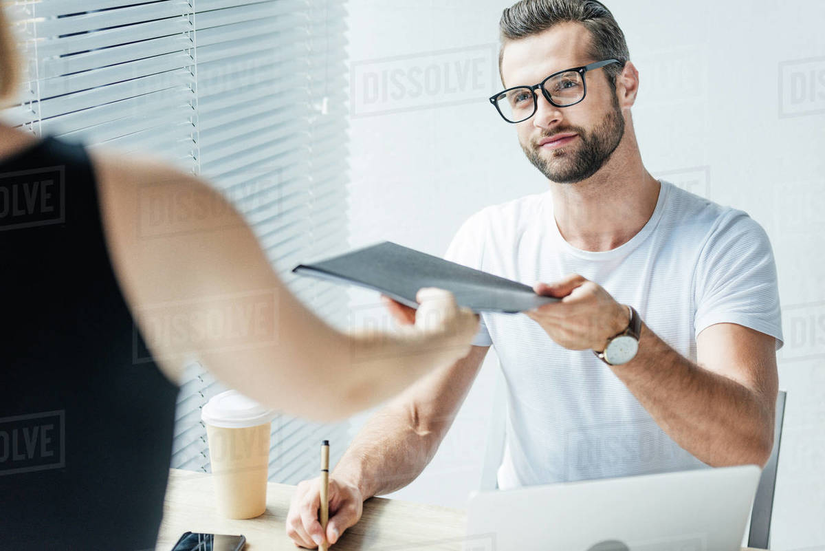 Handsome businessman giving documents to colleague in modern office ...