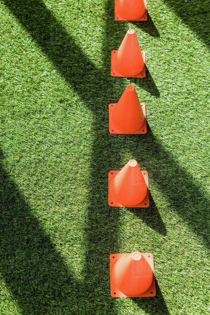 high angle view of row of safety cones standing on green grass - Stock ...