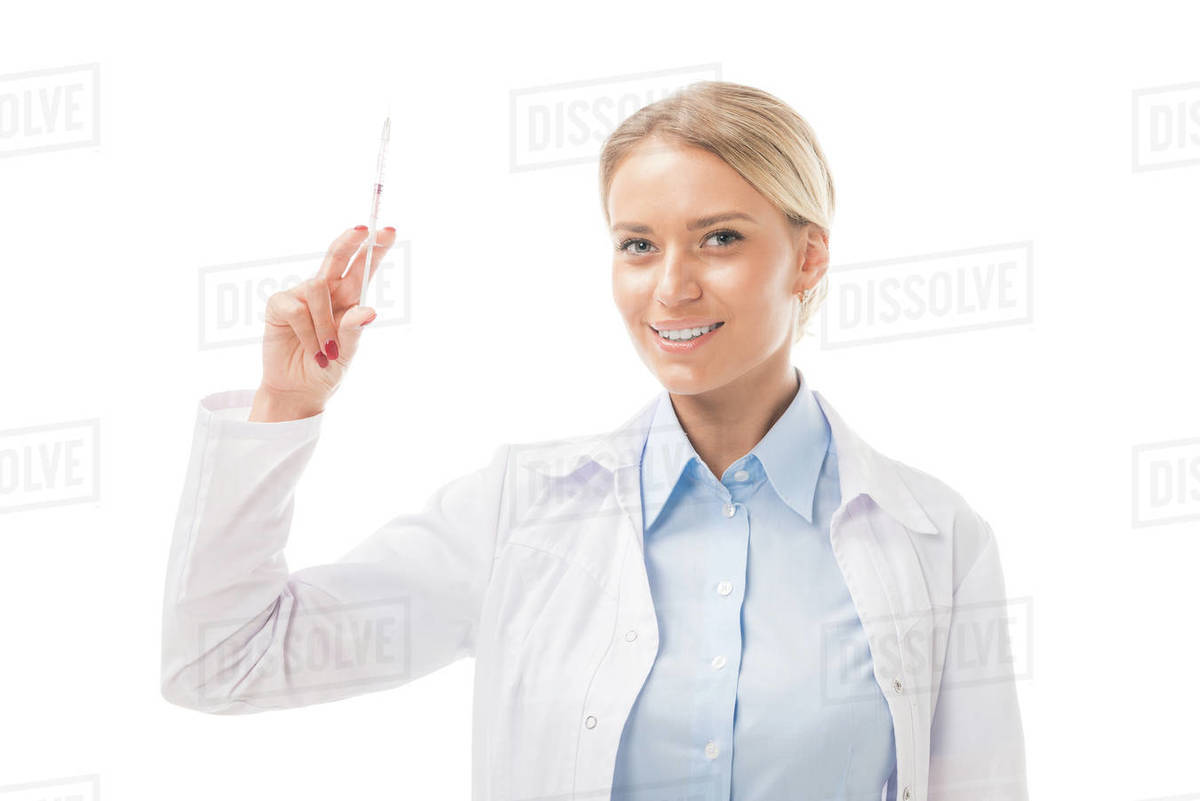 smiling young female doctor holding syringe and looking at camera ...