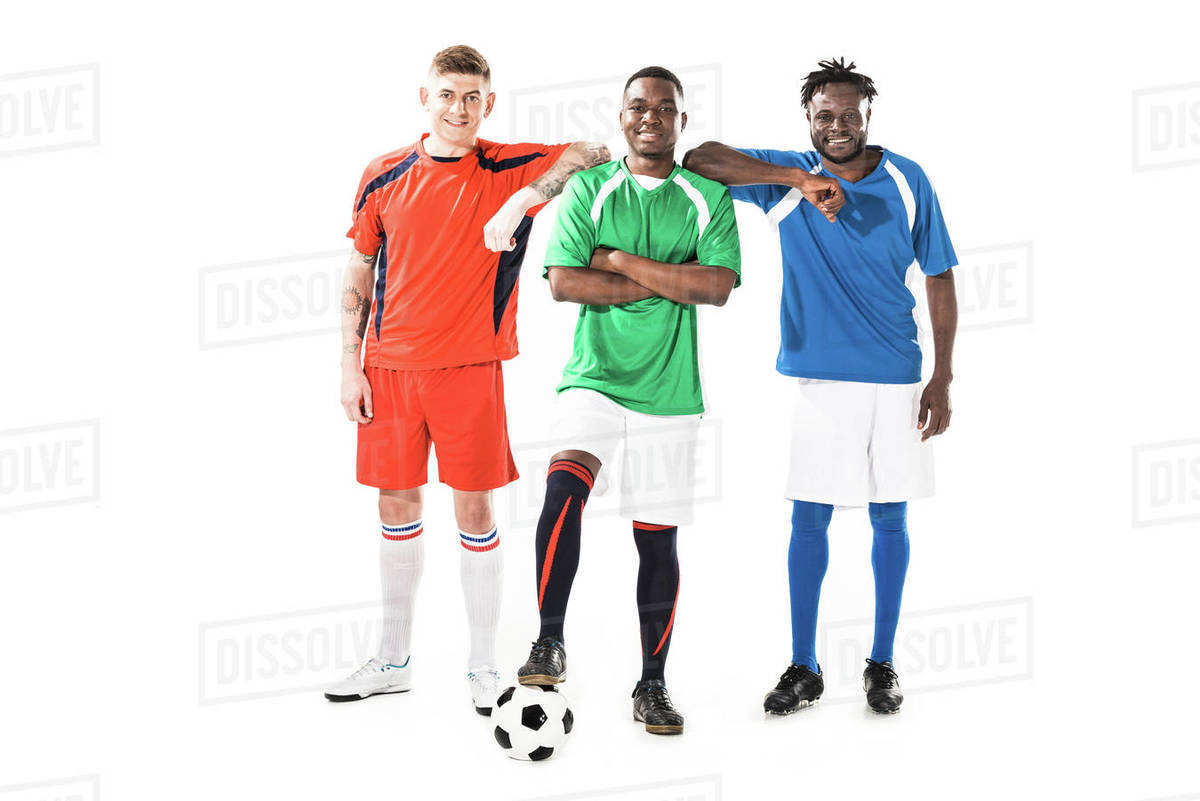 happy young multiethnic soccer players standing together and smiling at ...